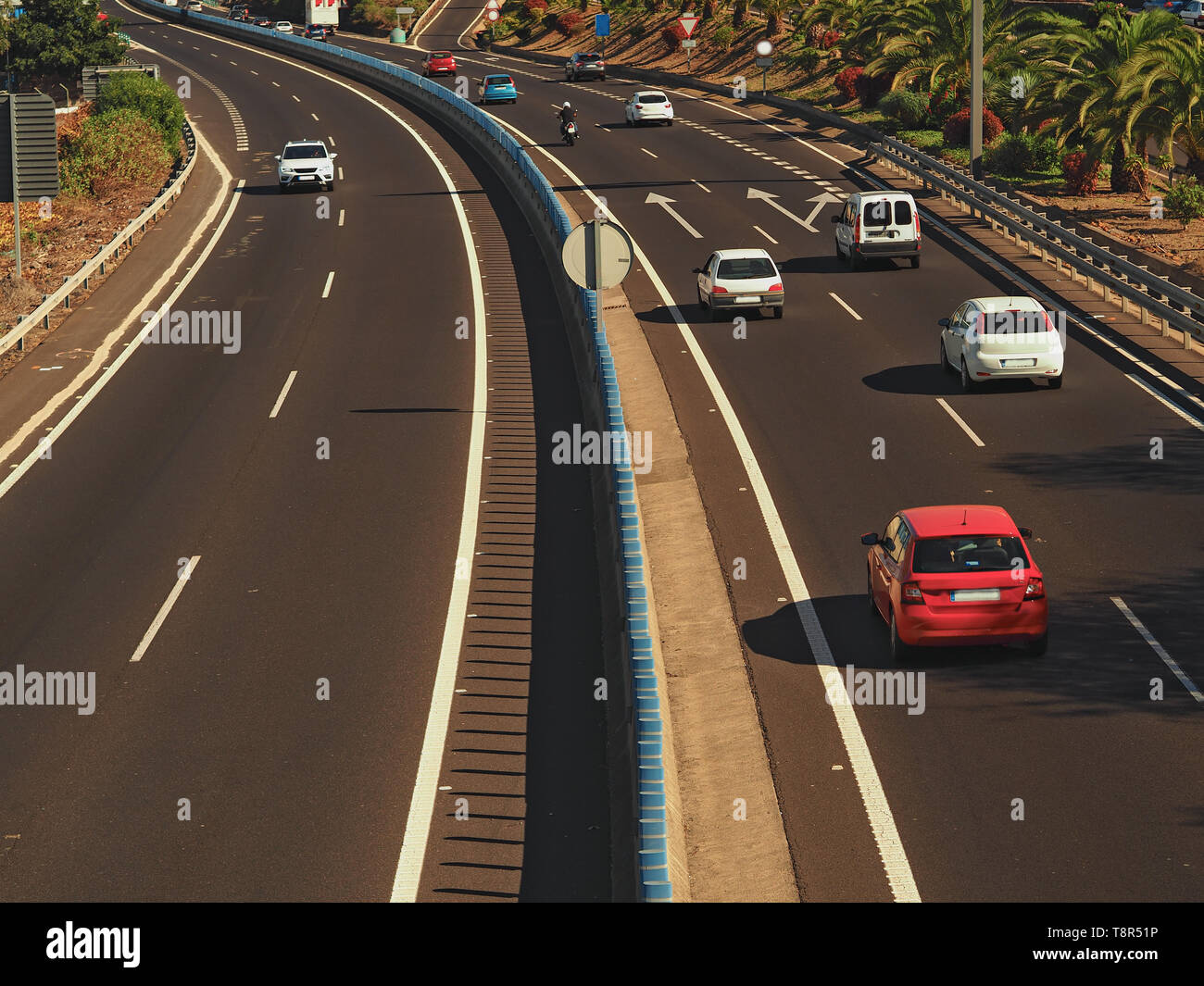 A view from a bridge on the little busy highway. On both sides of the ...