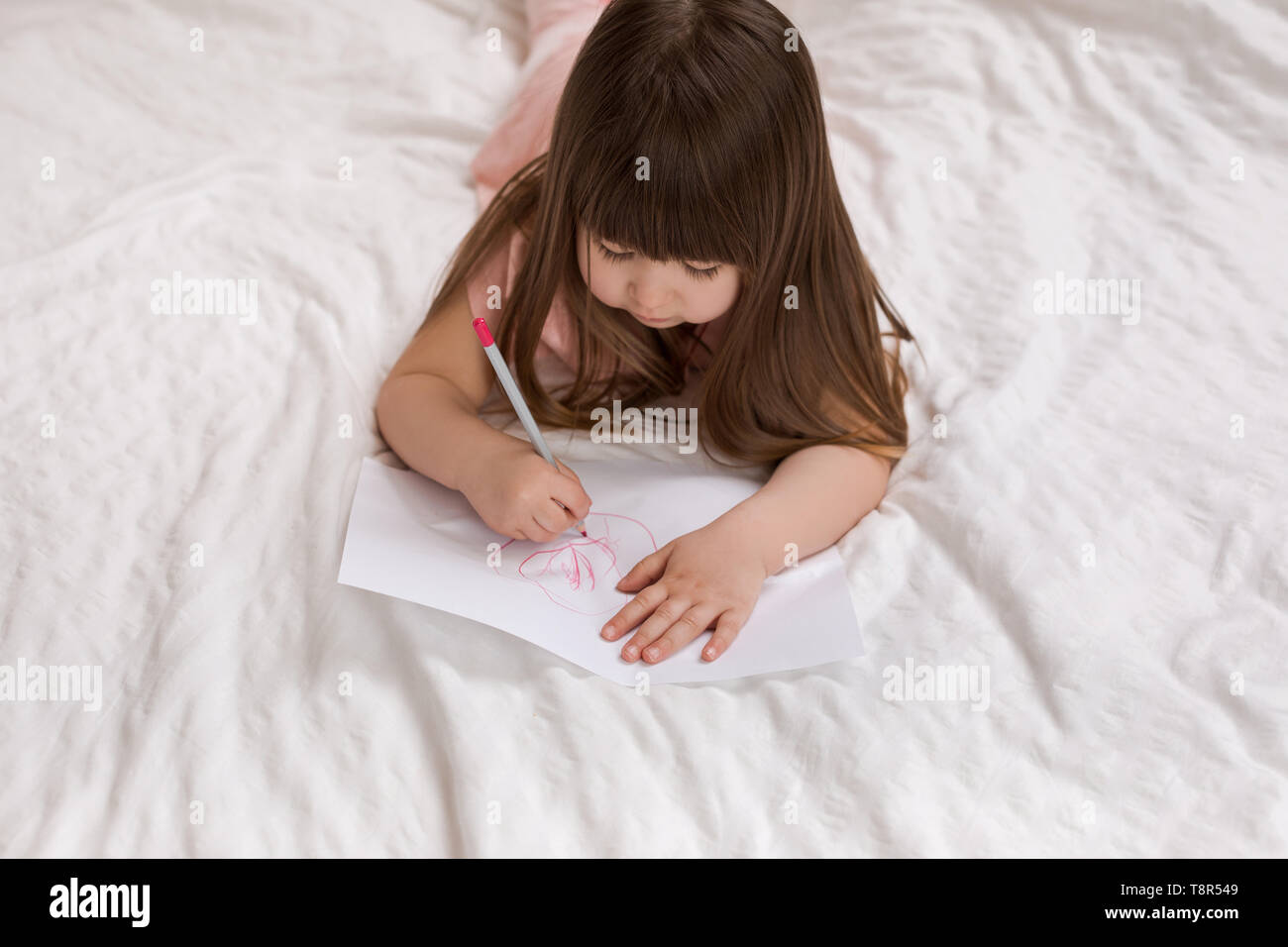 cute little girl drawing pictures while lying on bed. Kid painting at ... cute little girl drawing pictures while lying on bed. Kid painting at ...