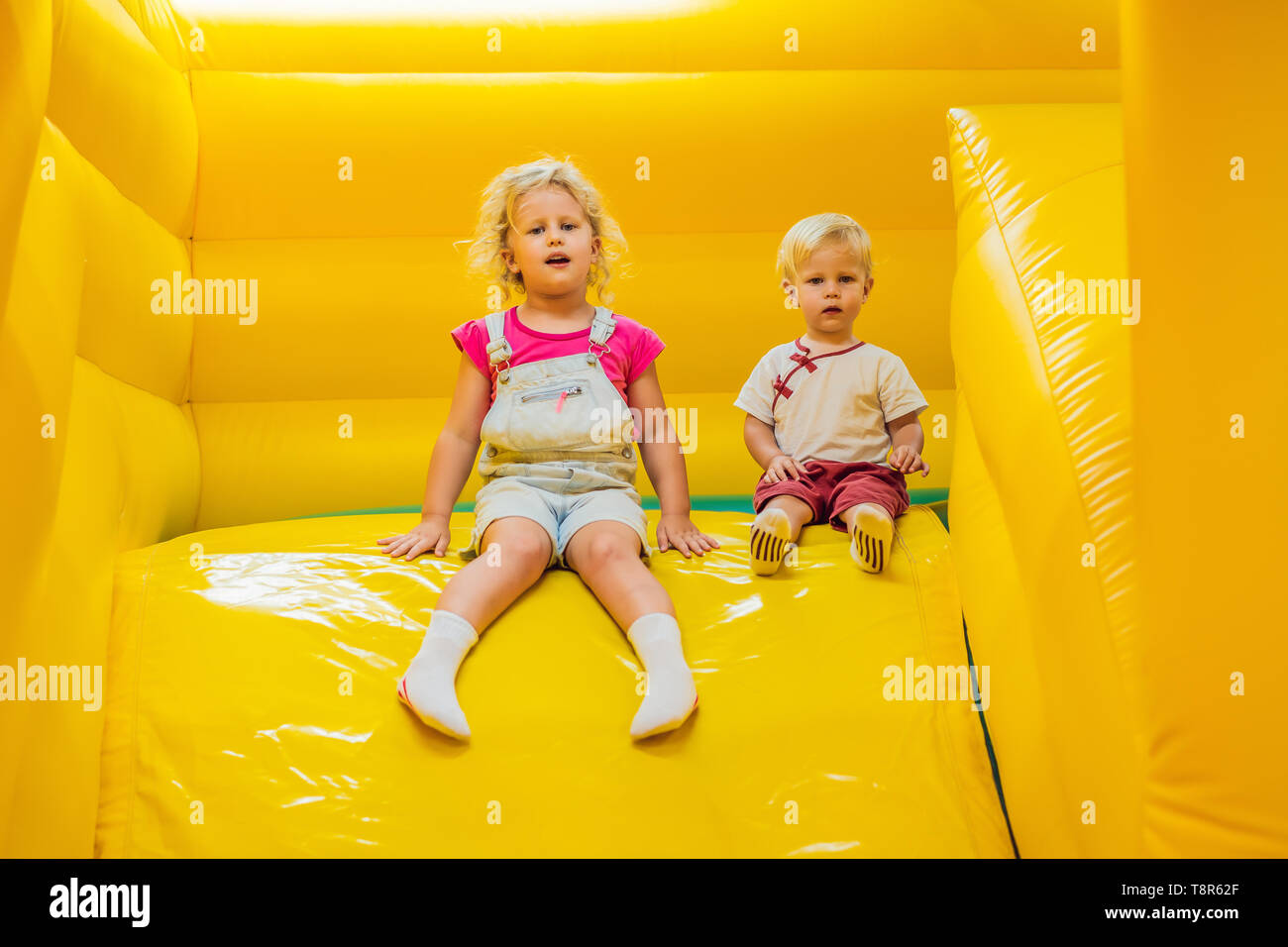 A boy and a girl ride from an inflatable slide Stock Photo - Alamy