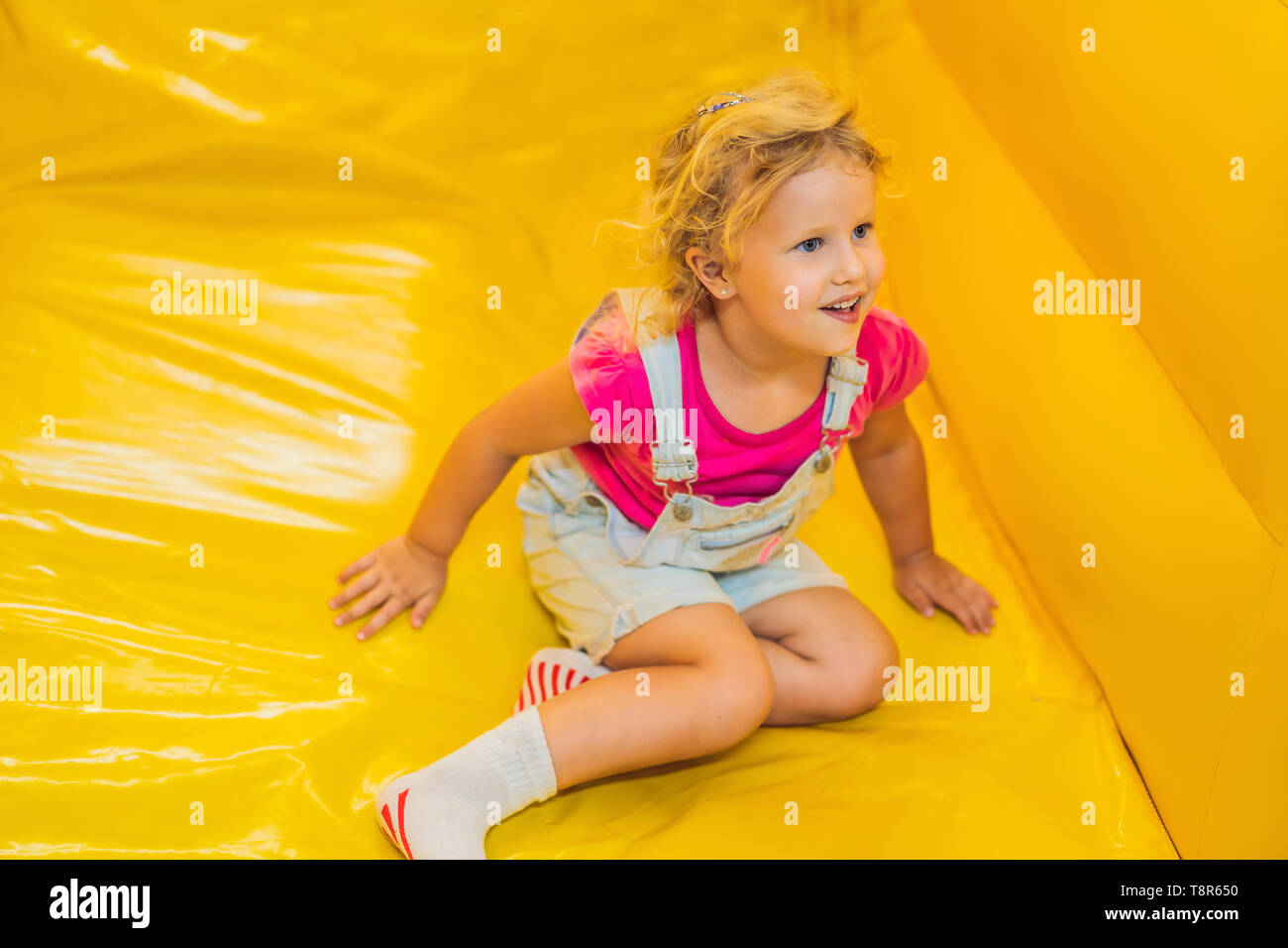 Little girl ride from an inflatable slide Stock Photo - Alamy