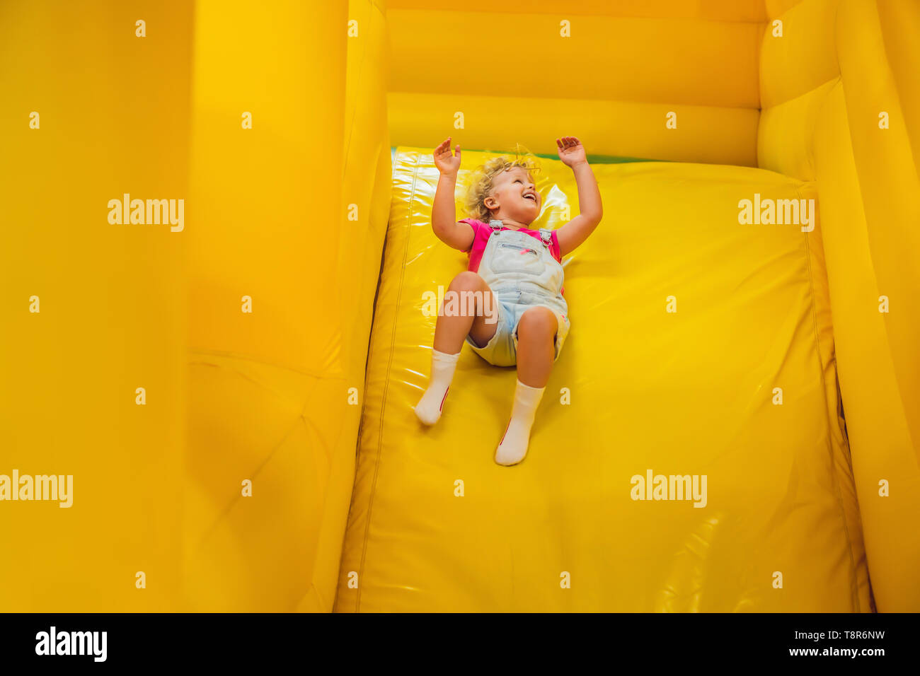 Little girl ride from an inflatable slide Stock Photo - Alamy