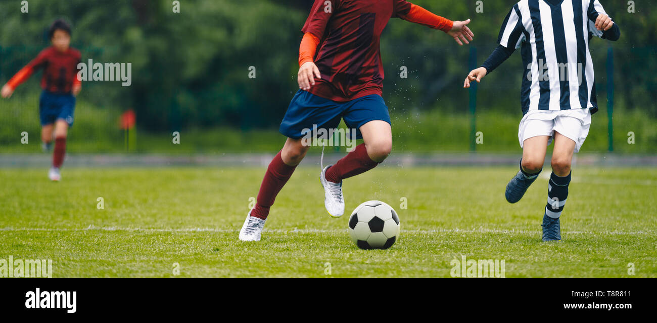 Soccer football players chasing ball on field Stock Photo - Alamy