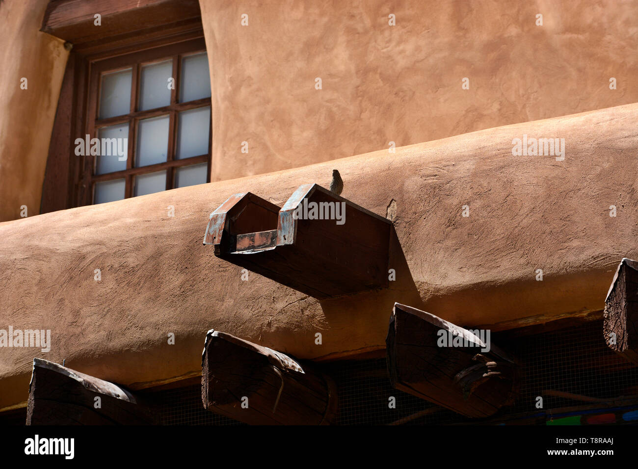 An historic adobe building with exposed vigas, or wooden roof beams ...