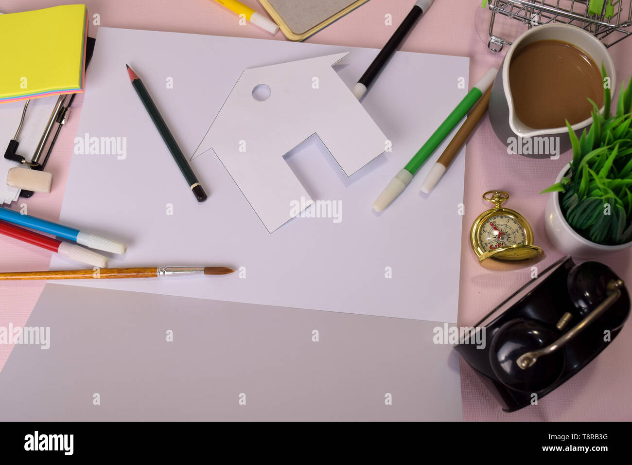 Top view of the cutting paper or drawing house on a pink table ...