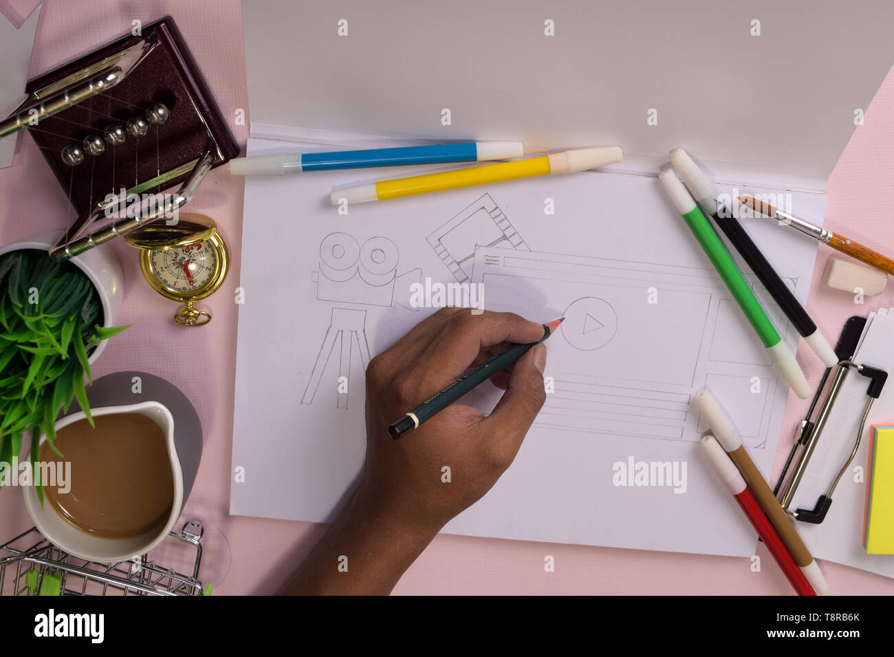 Top view of the man's hands drawing on a pink table, preparing to do ...