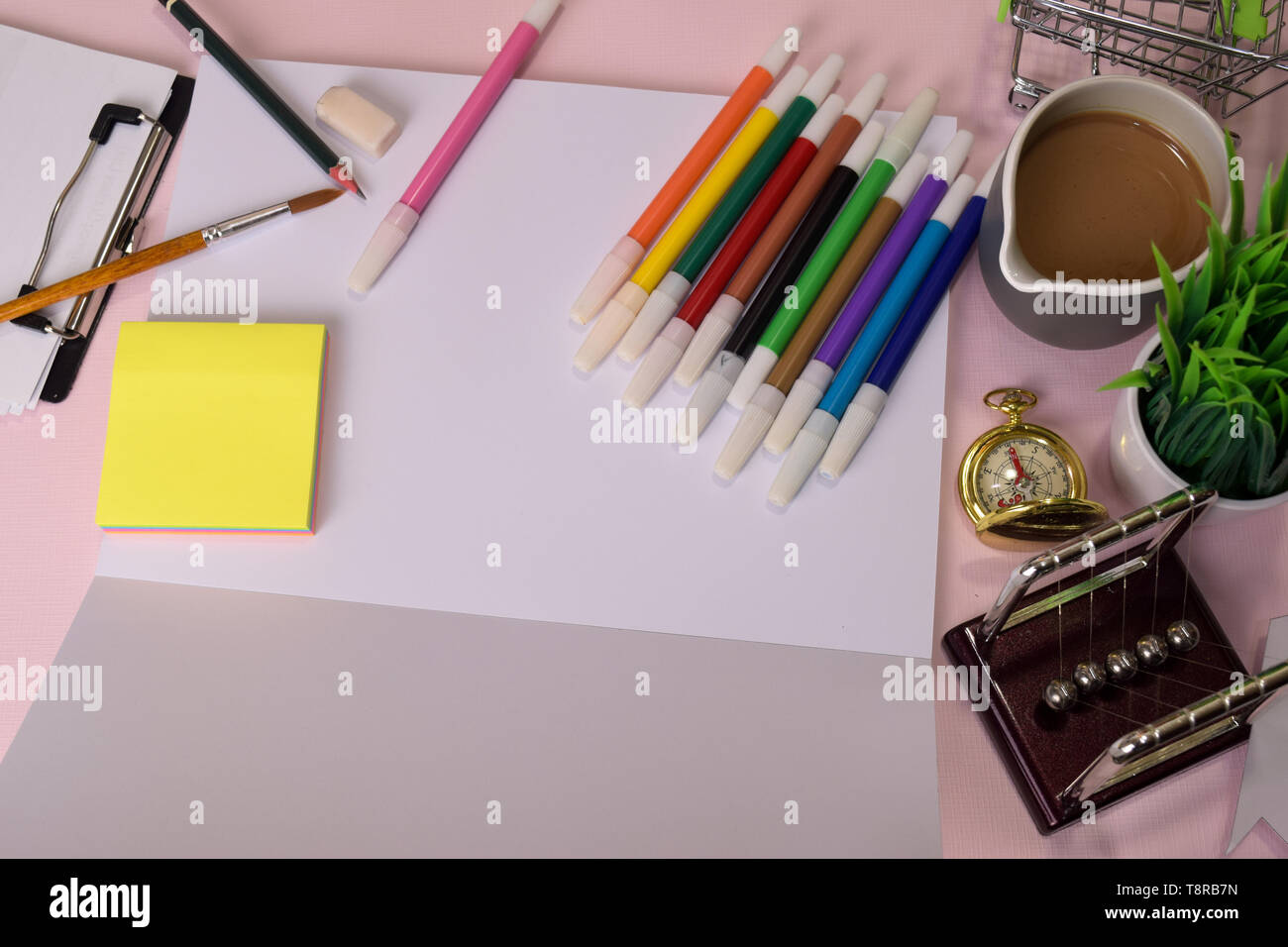 Top view of the open notebook with a marker drawing on a pink table ...