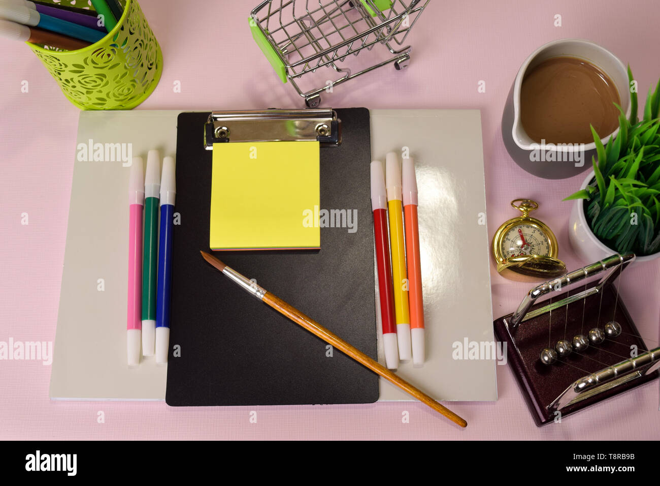 Top view of the notepad and clipboard with a marker drawing on a pink ...