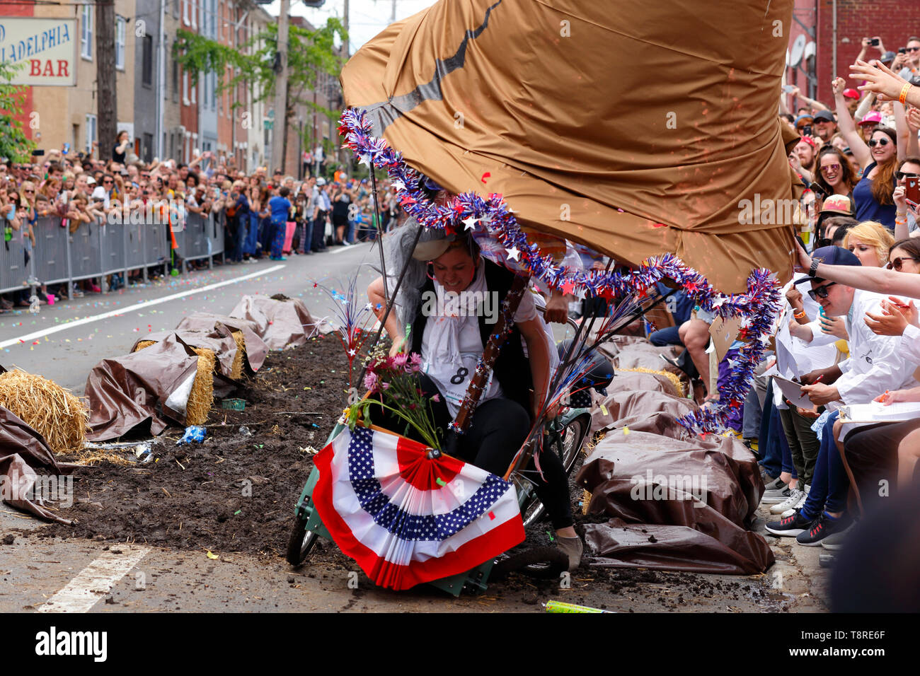 A participant gets up after their art bike collapses at the end of the mud pit challenge in 2019 ...