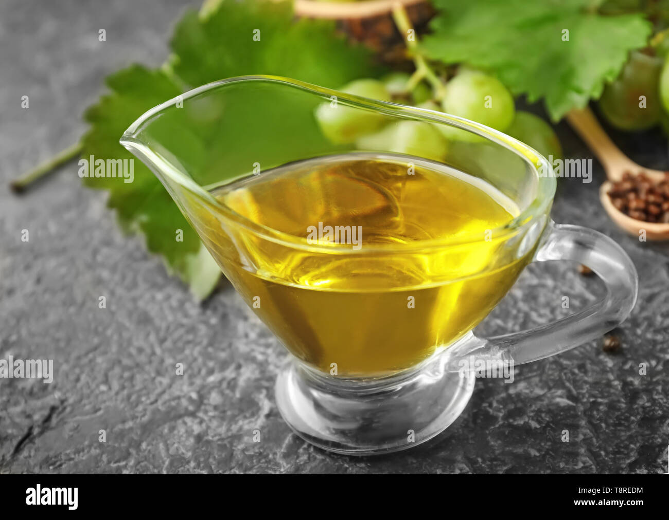 Gravy boat with grape seed oil on table Stock Photo - Alamy