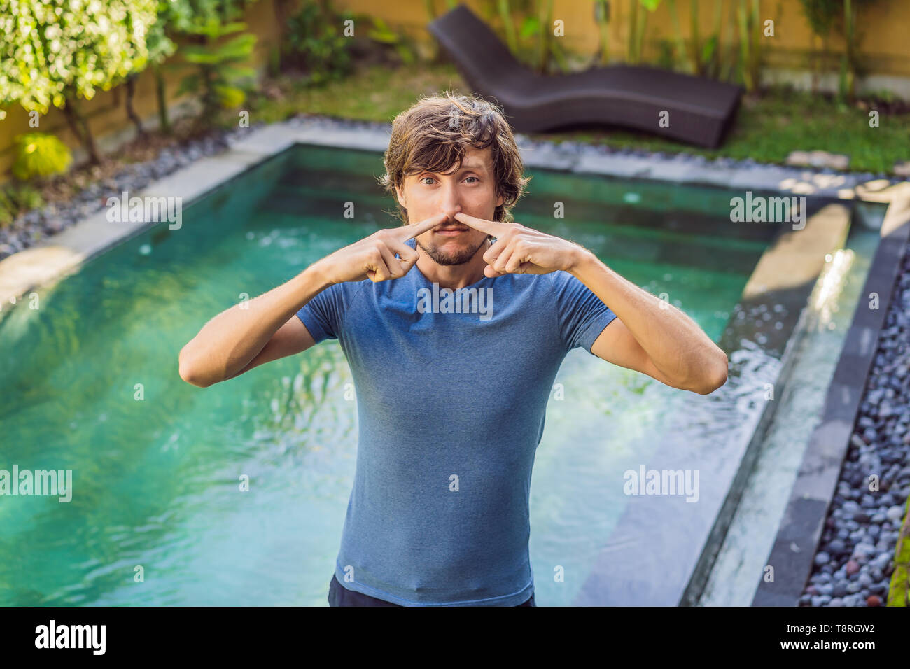 Young man with disgust on his face pinches nose, something stinks, very ...