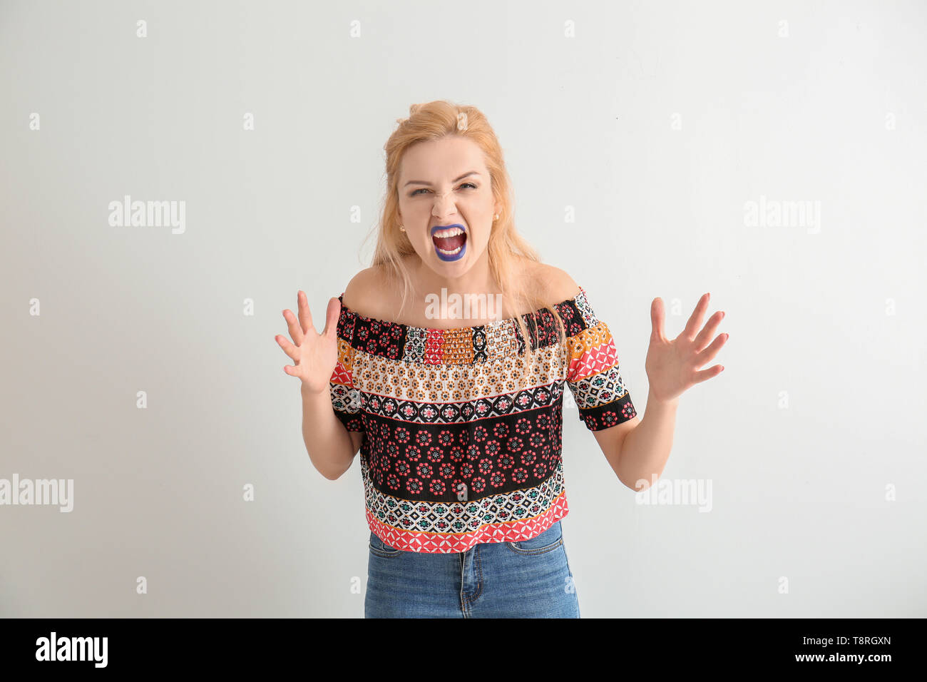 Portrait of beautiful aggressive woman with unusual lipstick on white ...