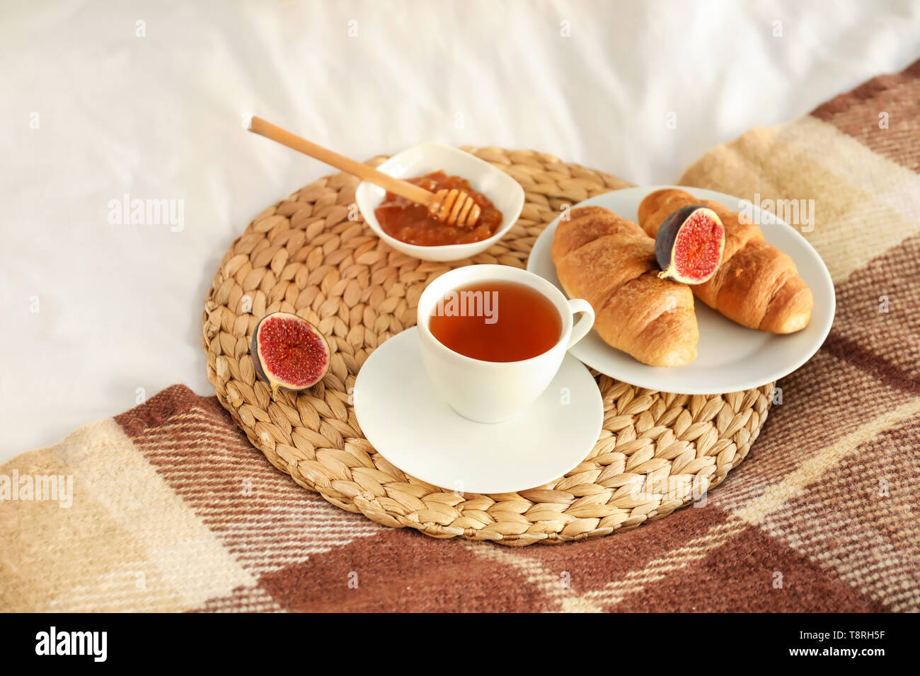 Wicker mat with delicious breakfast on bed Stock Photo - Alamy