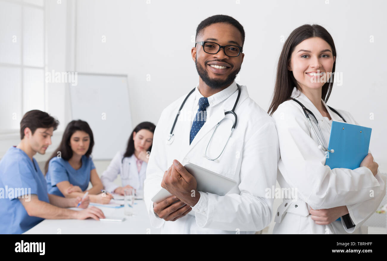 Two Doctors In White Coats Posing To Camera At Conference Stock Photo ...