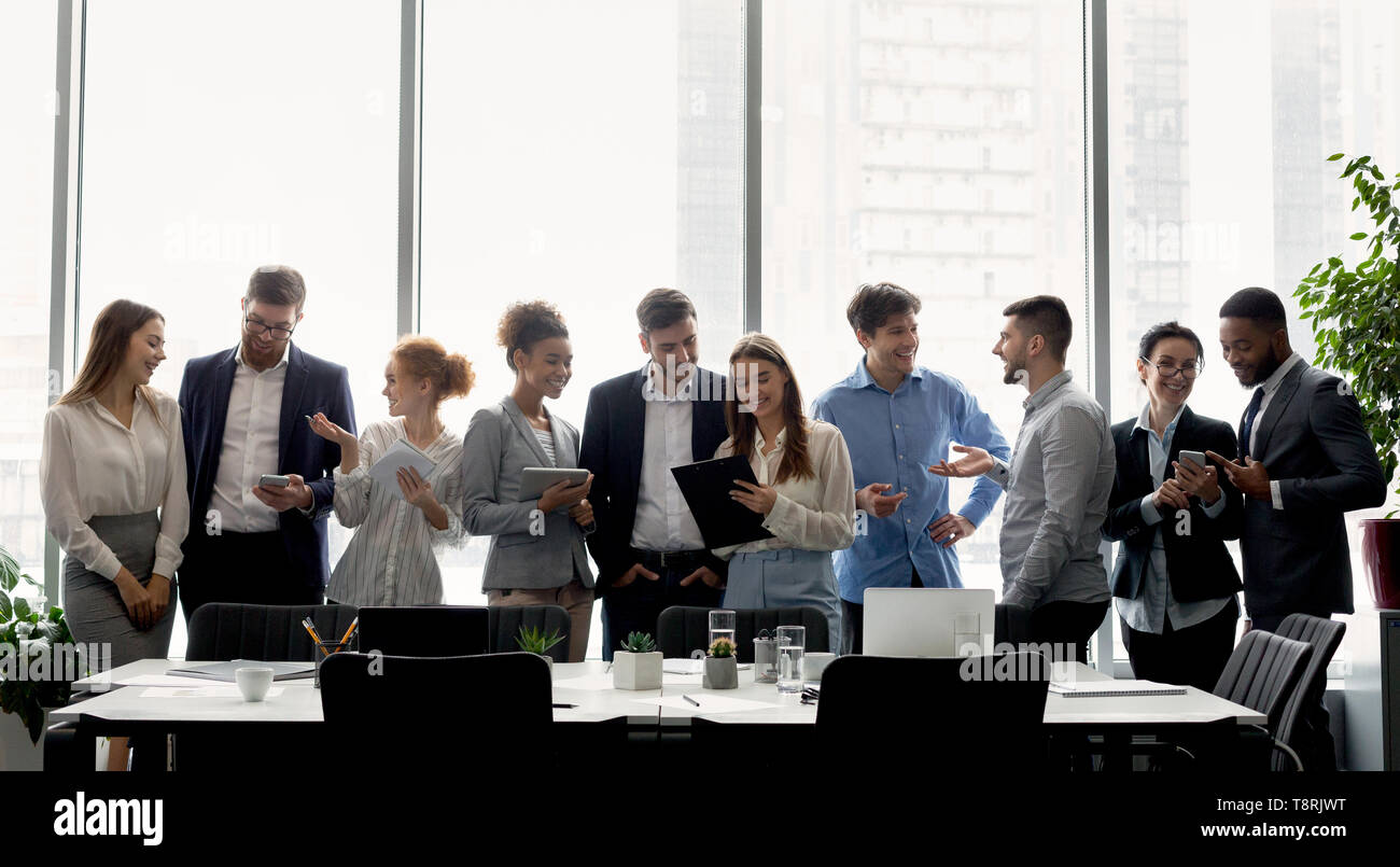 Business team having break, standing near window Stock Photo - Alamy