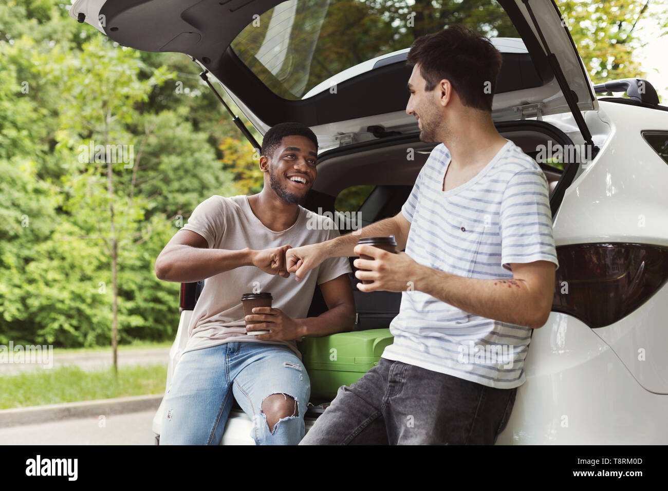 Multicultural friends standing near car Stock Photo - Alamy