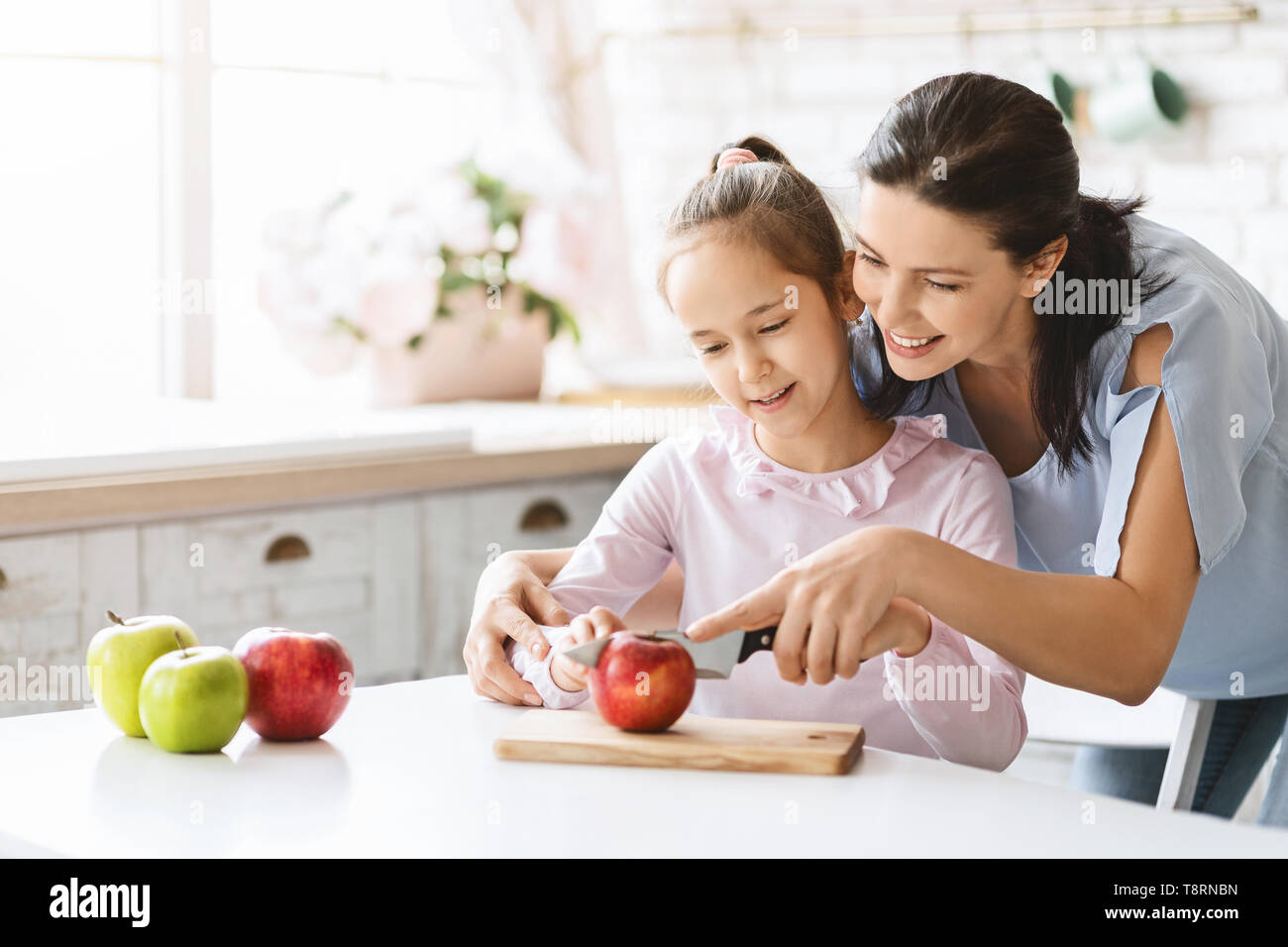 Mom Teaching Cute Girl To Cut Apple With Knife Stock Photo - Alamy