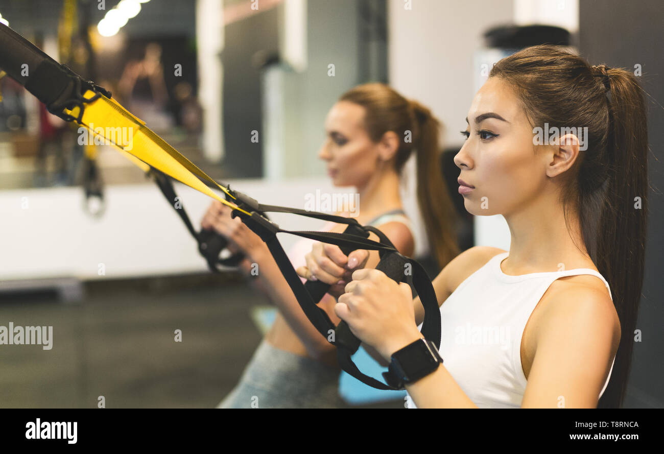 Fit woman doing exercises with trx system Stock Photo - Alamy