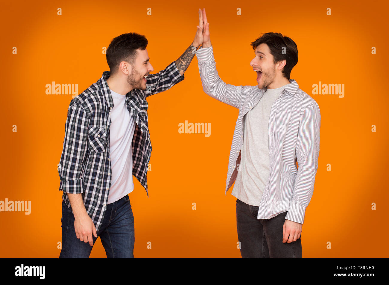 Happy Friends Giving High Five, Orange Background Stock Photo - Alamy