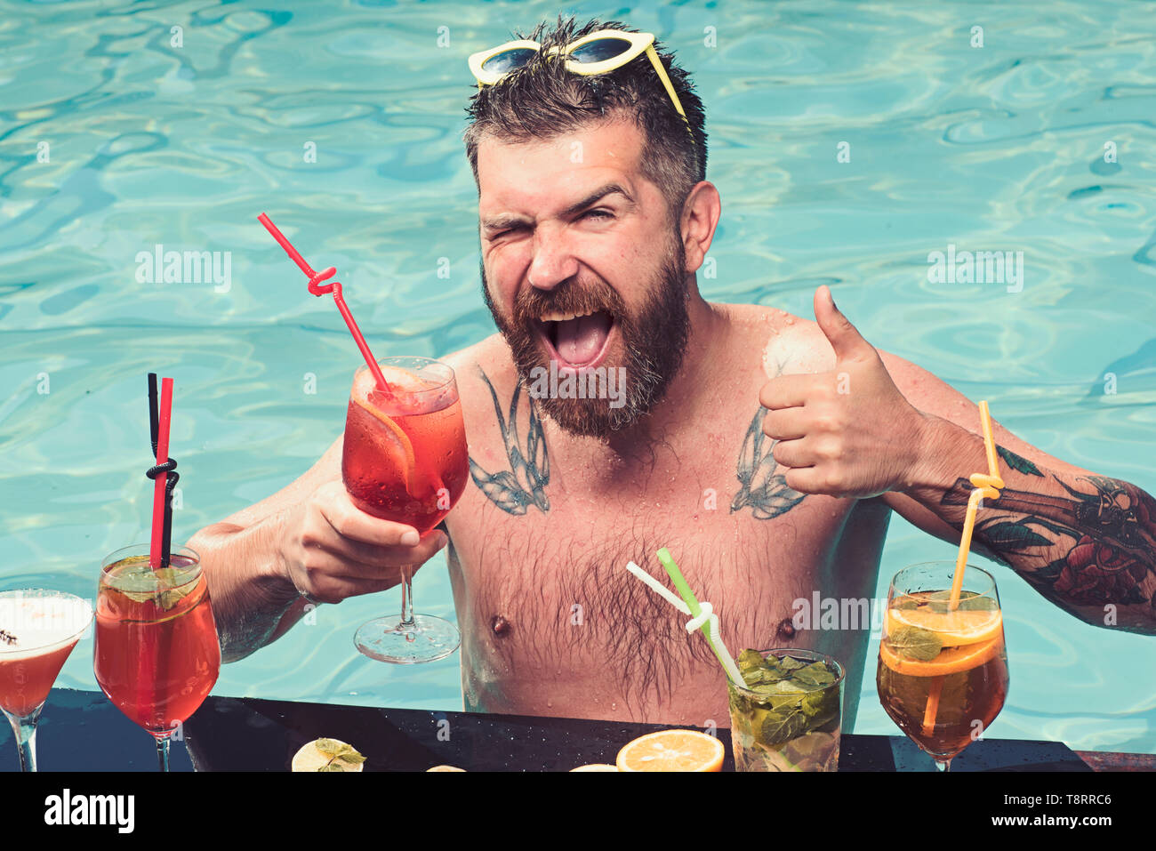 Cocktail with fruit at bearded man in pool. cocktail party on summer ...