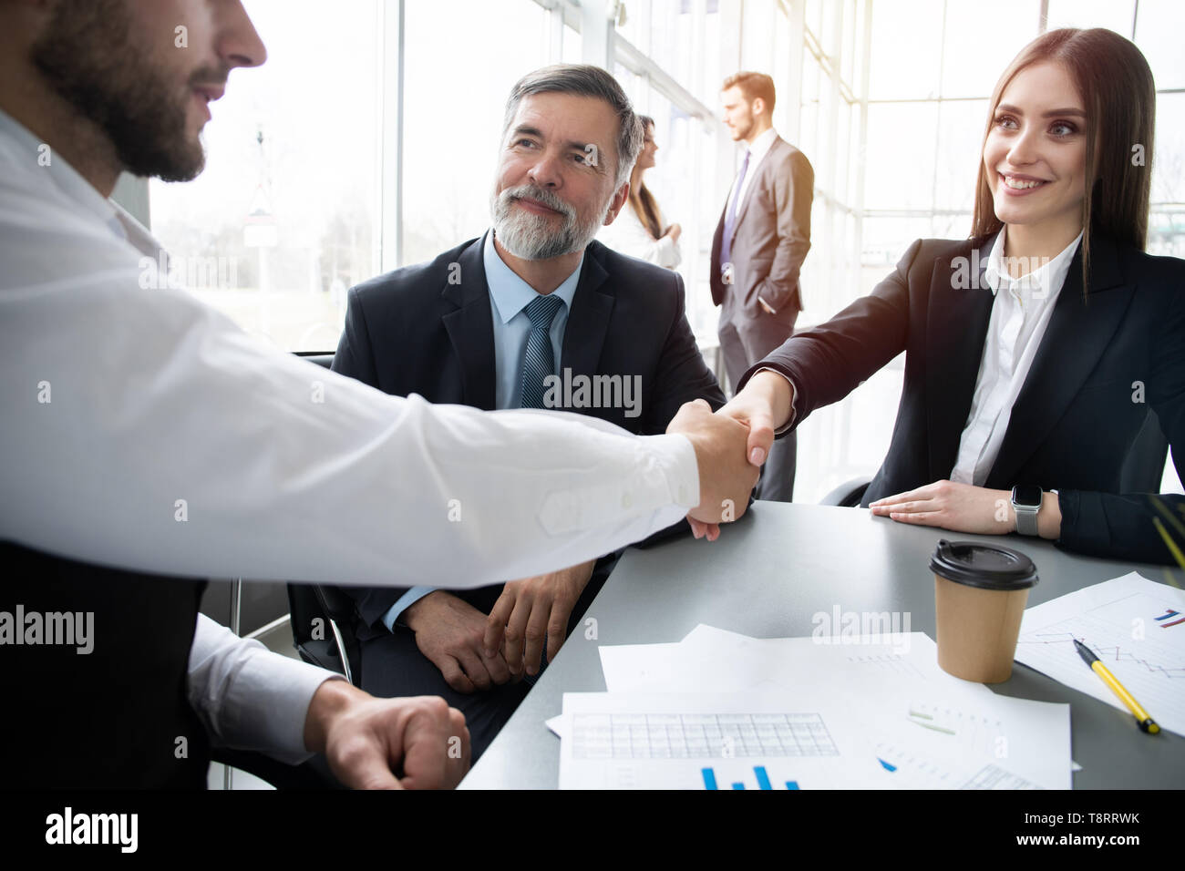 Business people shaking hands while working in the creative office ...
