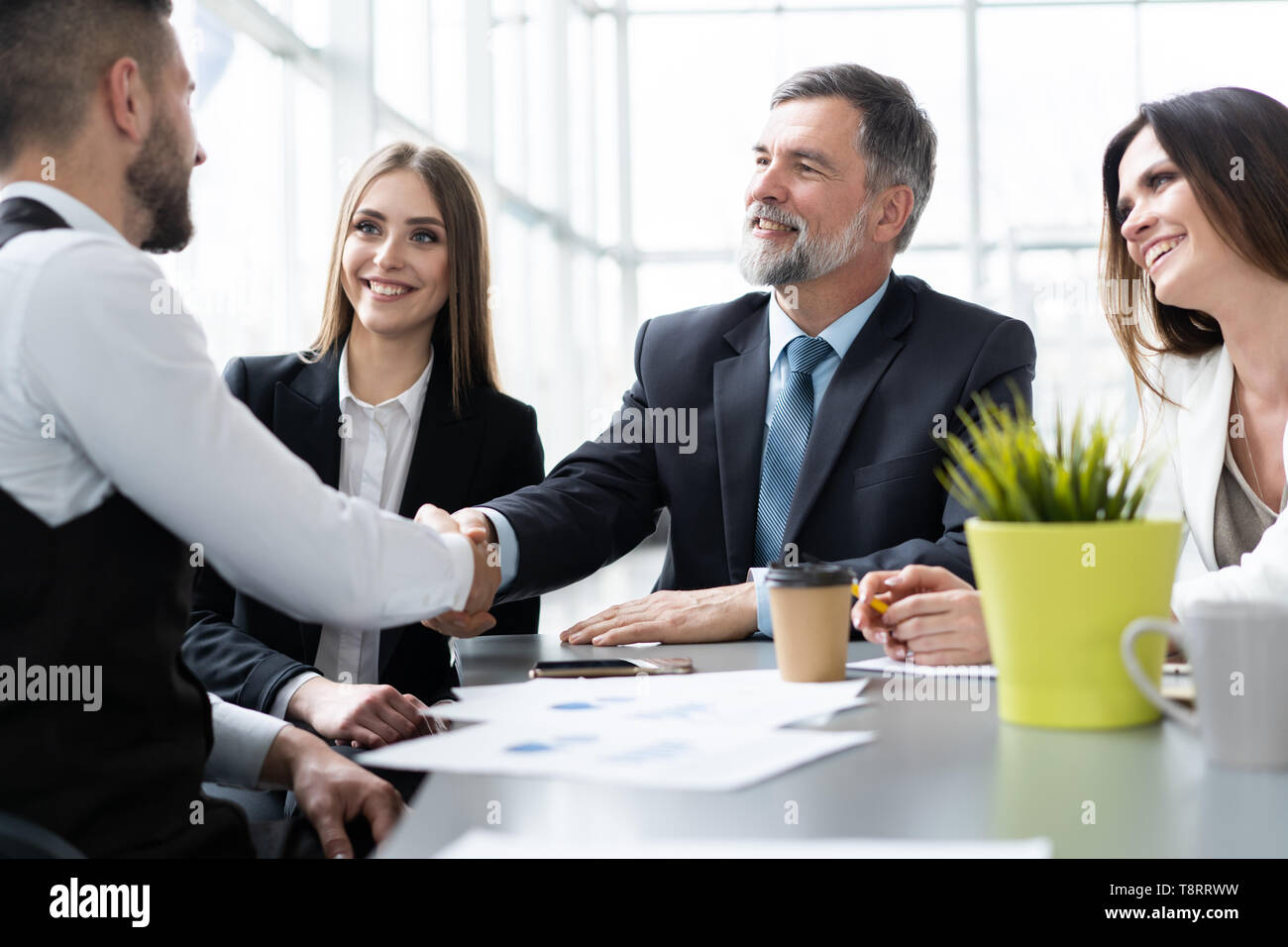 Business people shaking hands while working in the creative office ...
