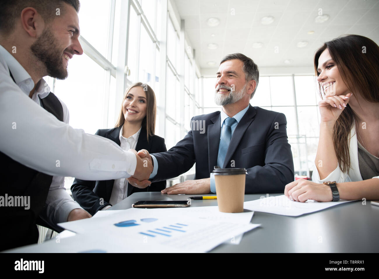 Business people shaking hands while working in the creative office ...