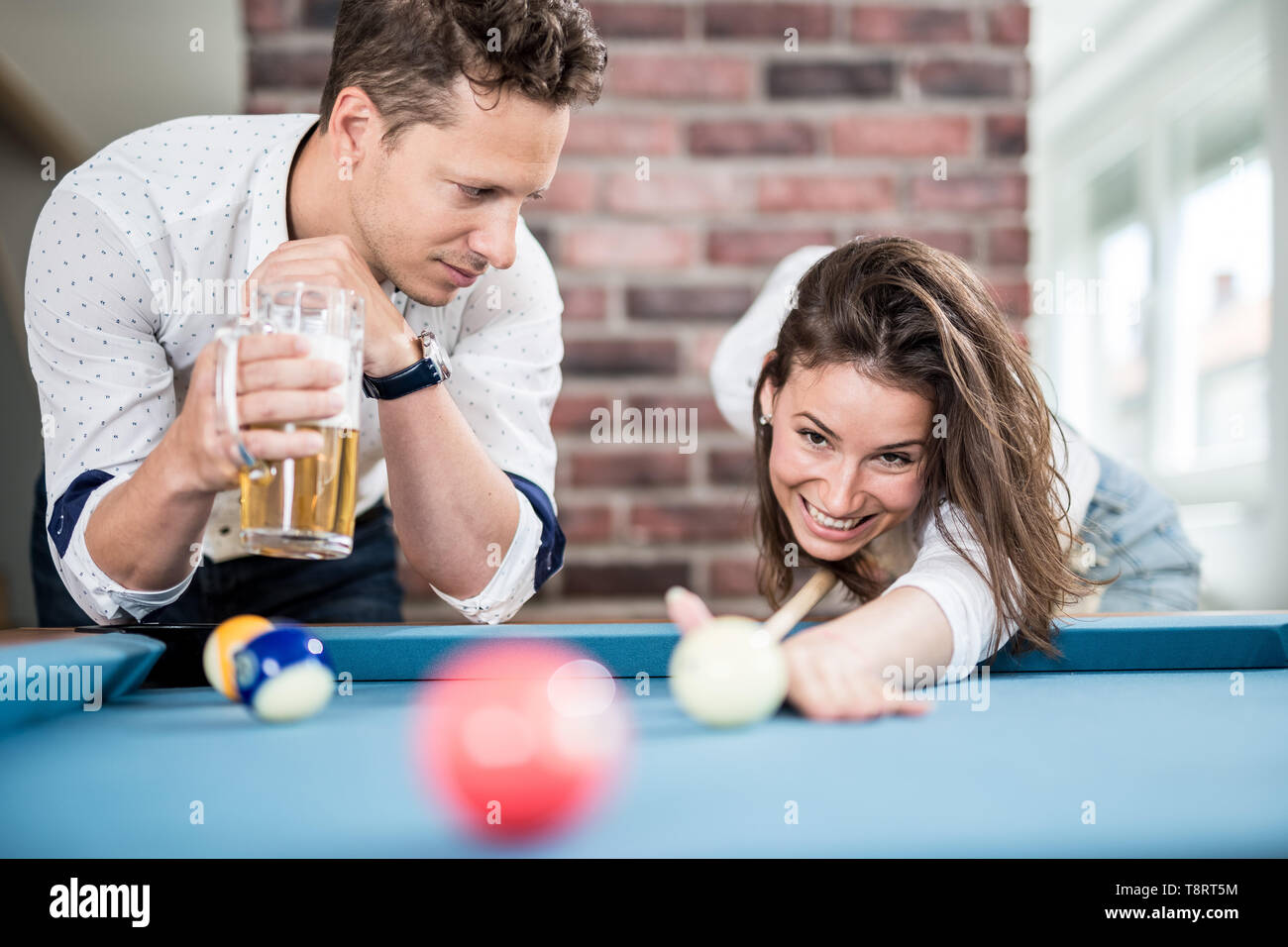 Couple playing snooker game and drinking beer Stock Photo - Alamy
