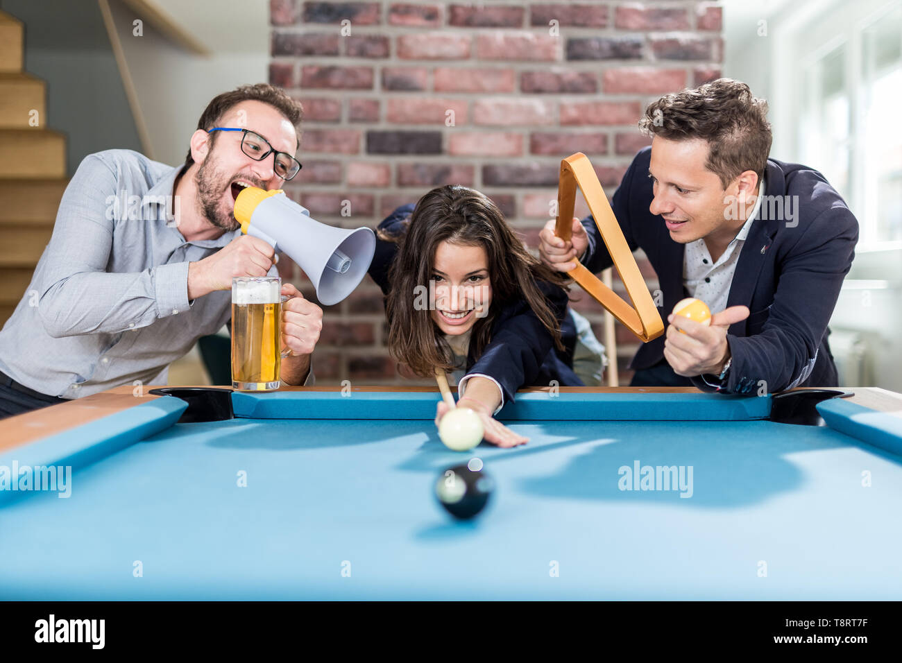 Happy friends enjoying playing snooker game Stock Photo - Alamy