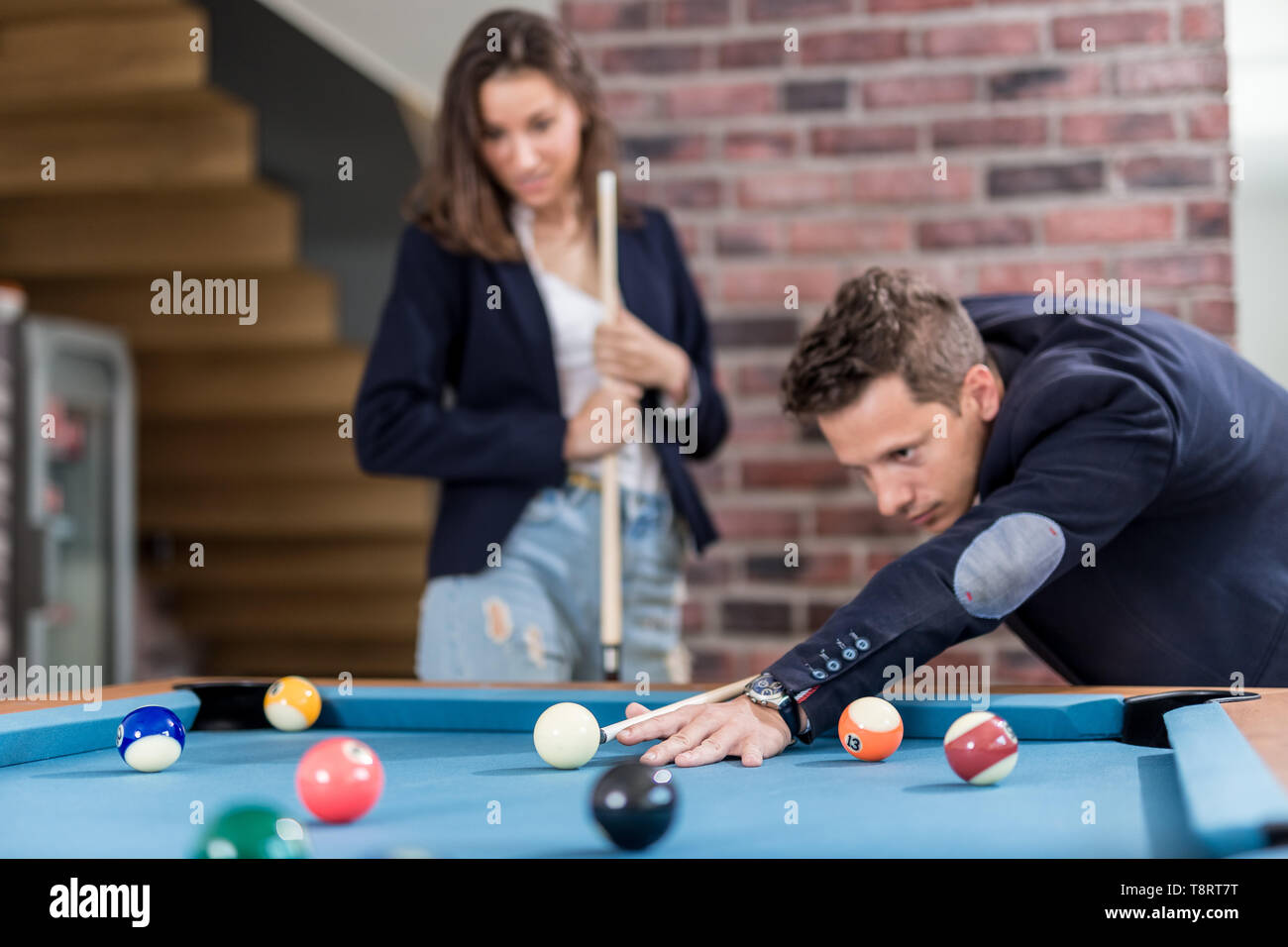 Young modern couple playing pool table billiard game Stock Photo - Alamy
