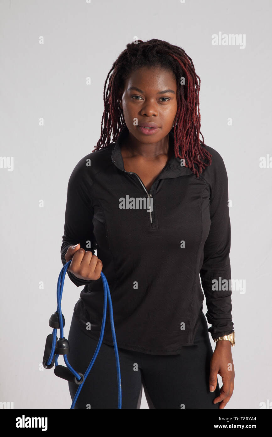 Lovely Black woman in exercise outfit with a pull rope Stock Photo - Alamy