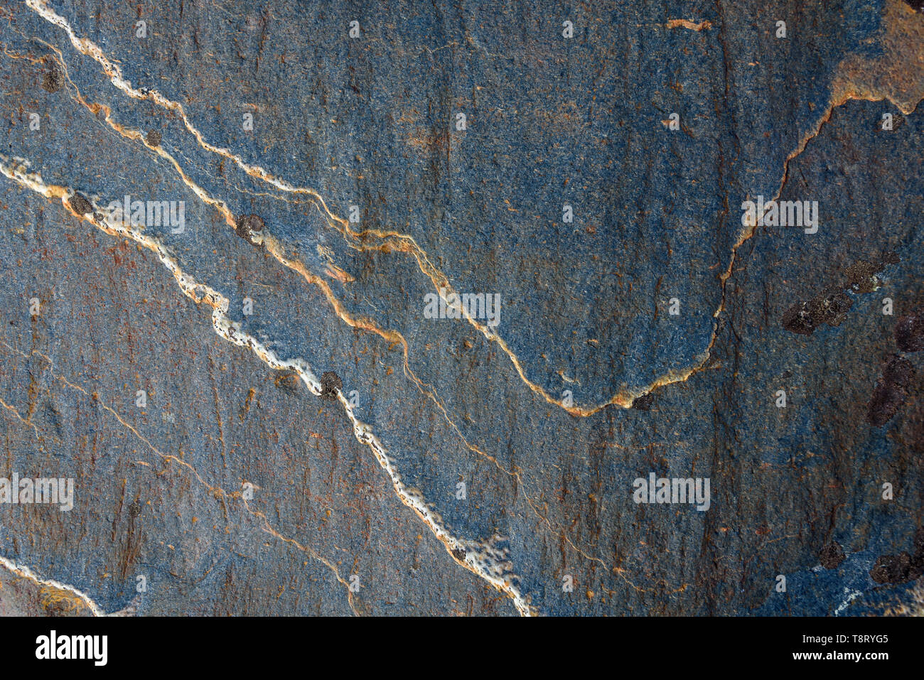 Blue gray stone with white and orange lines of pattern and texture as a ...