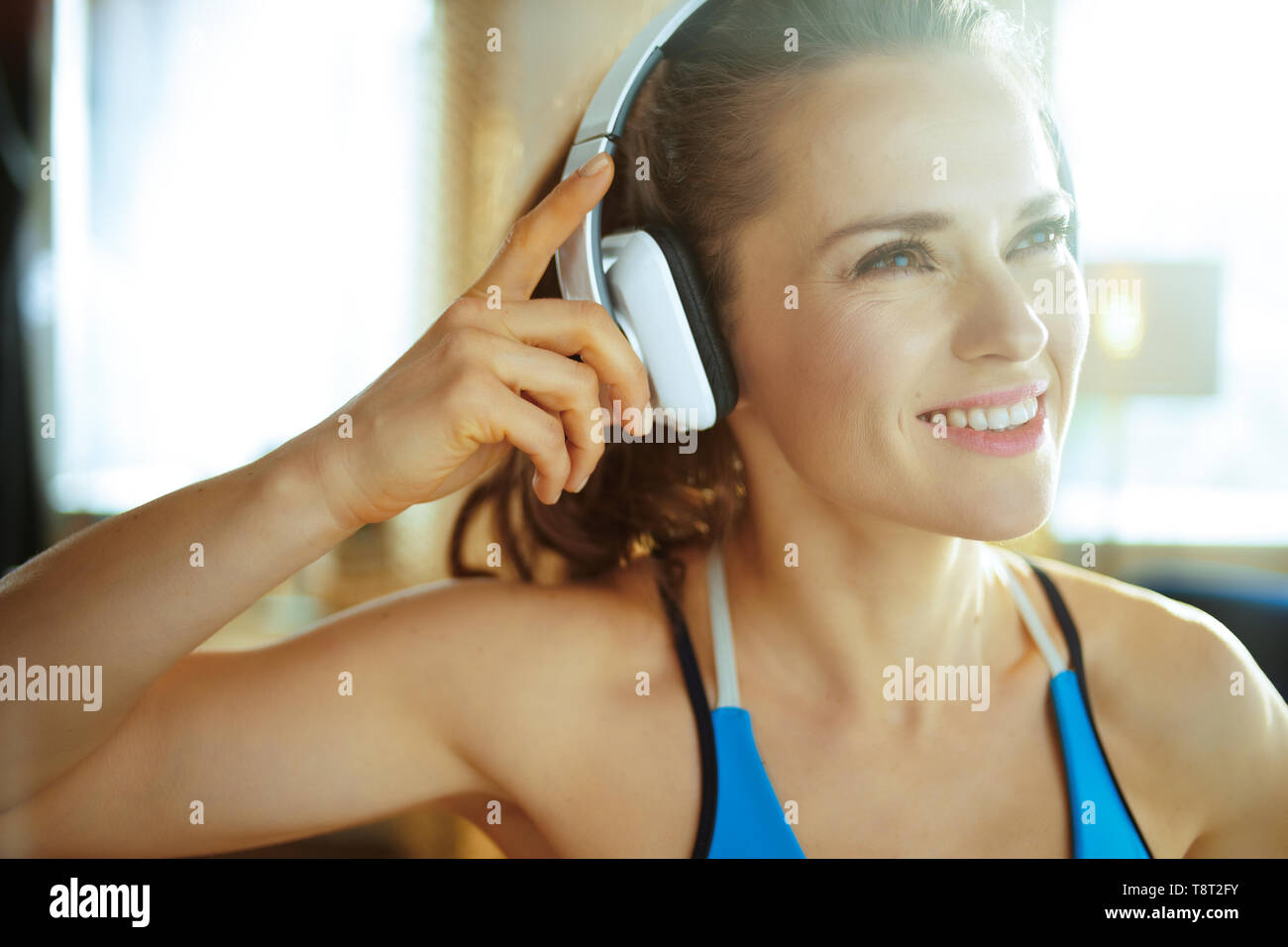 happy fit woman in fitness clothes listening to the music with ...