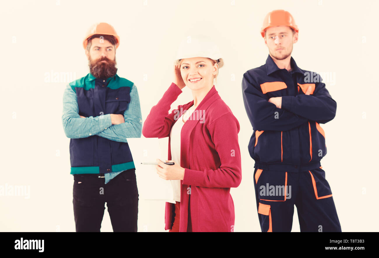 Woman in hard hat with smiling face stand in front of male builders in ...