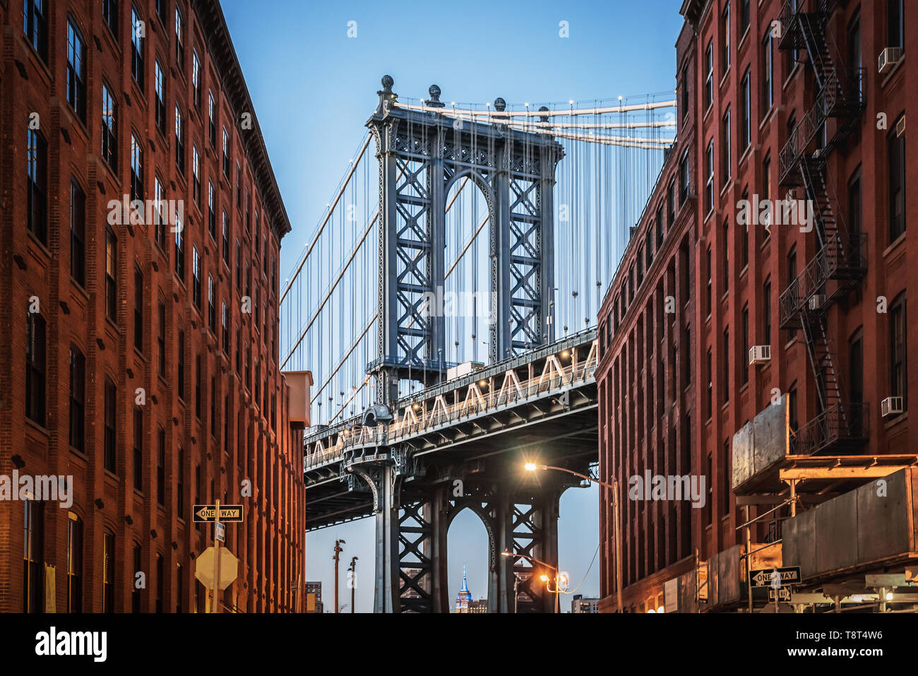 Dumbo - The famous Manhattan bridge between two red brick buildings in Brooklyn in the evening ...