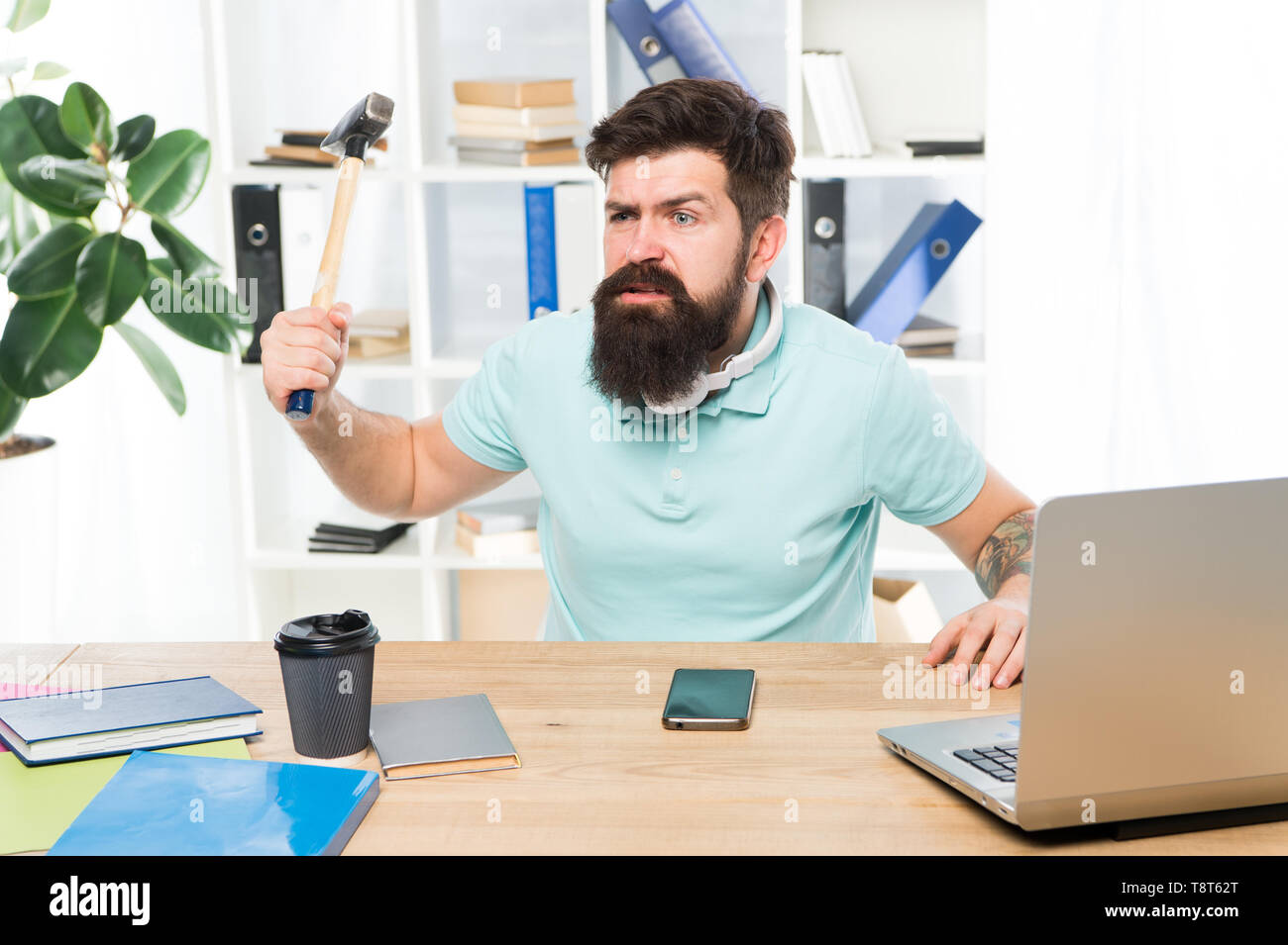 Businessman with beard and mustache gone mad with hammer in a hand ...