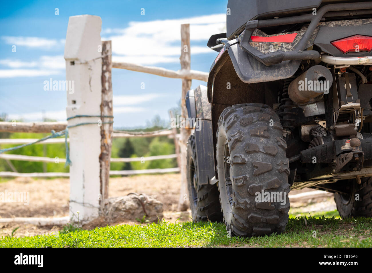 ATV quad bike vehicle standing near wooden fence at farm or horse ...