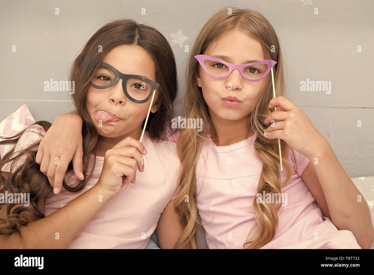 Playful mood. Girls children posing with grimaces photo booth props ...