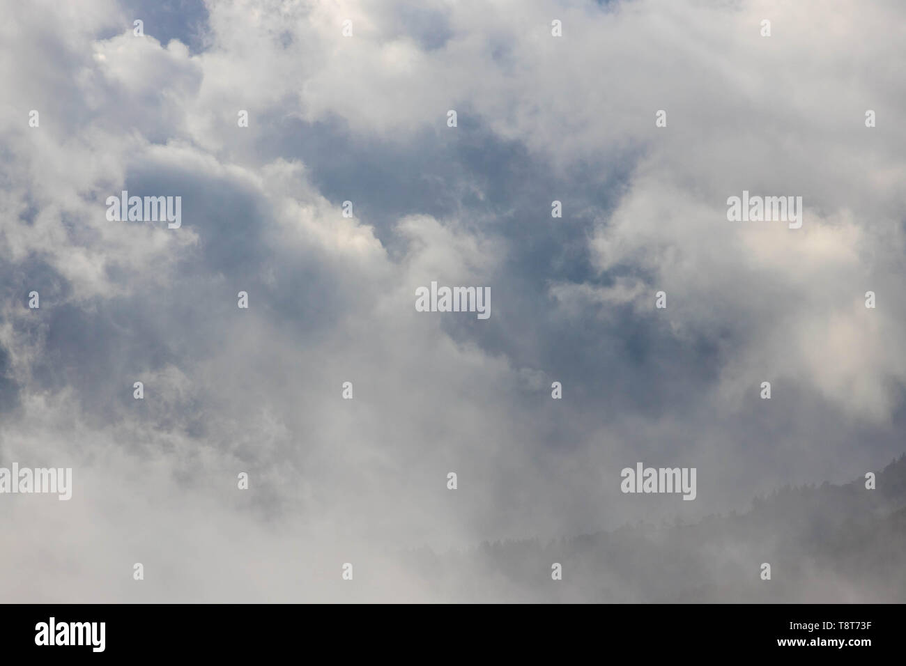 Low clouds mix with early morning mist rising from mountainside Stock ...