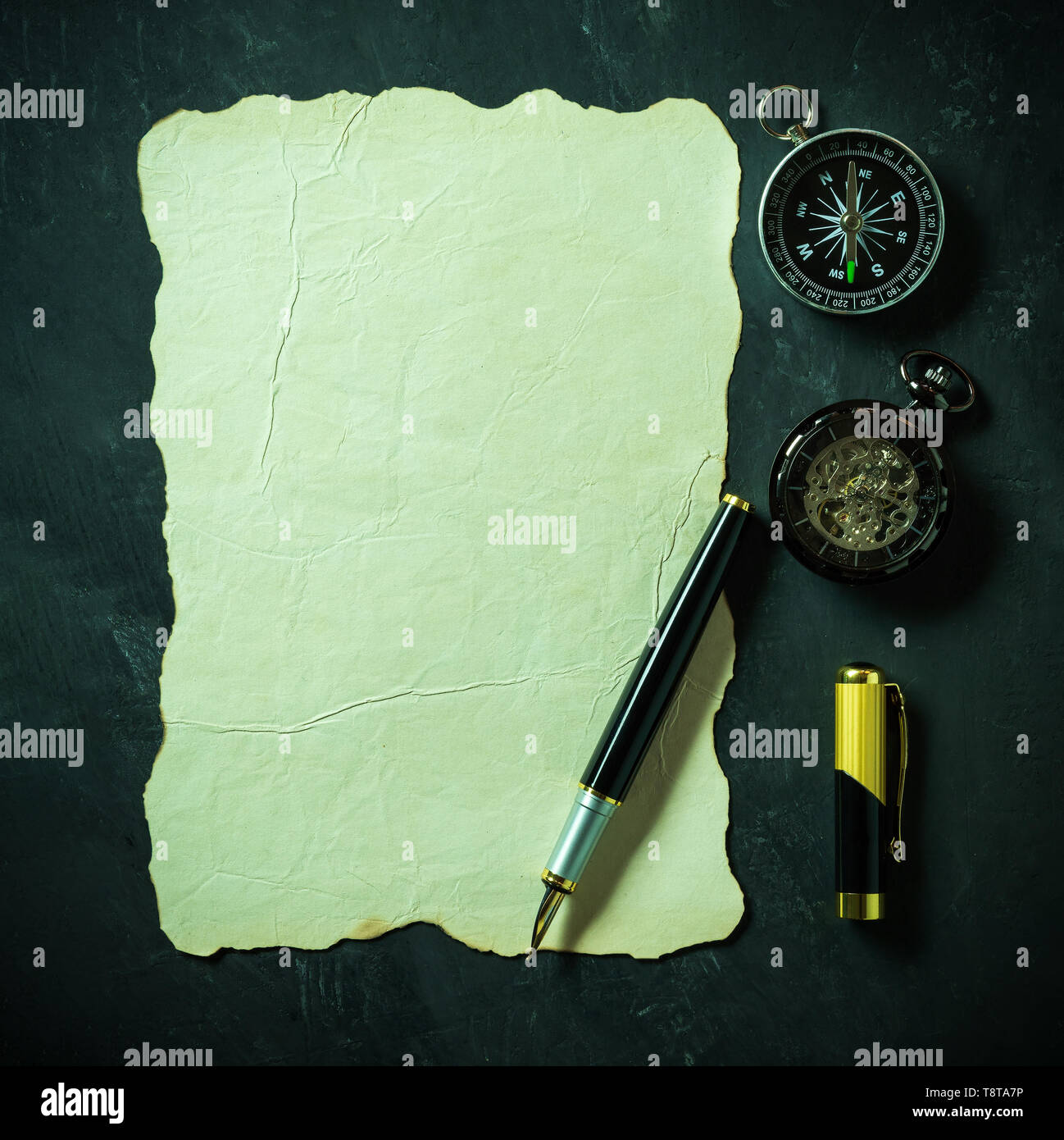 Vintage paper and pen with compass and pocket watch on black background ...