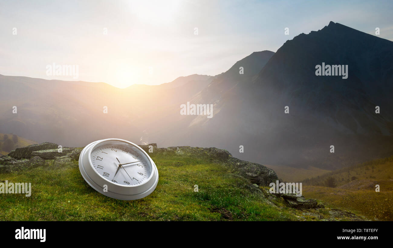 Clock on the ground with mountain landscape view Stock Photo - Alamy