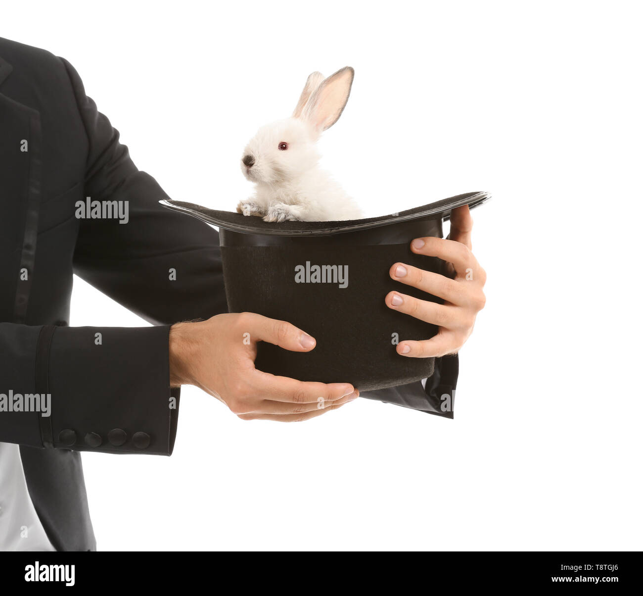 Magician holding hat with rabbit on white background Stock Photo - Alamy