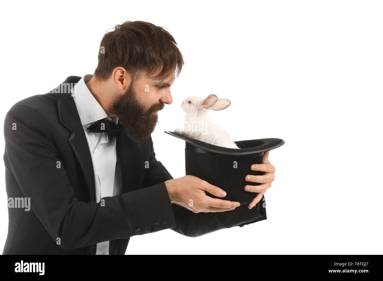 Magician holding hat with rabbit on white background Stock Photo - Alamy