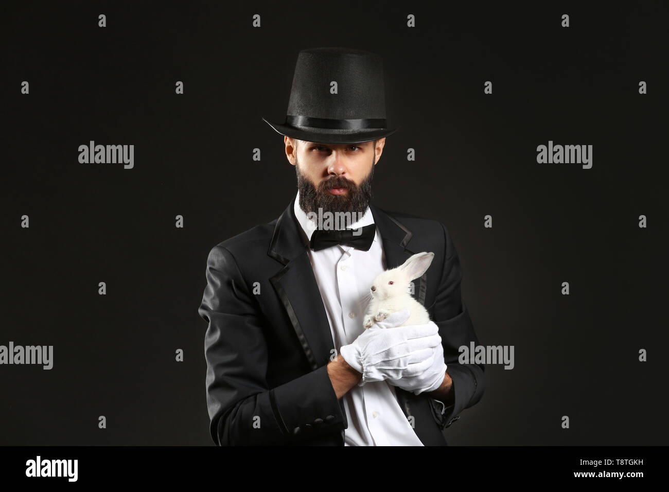 Magician with rabbit on dark background Stock Photo - Alamy