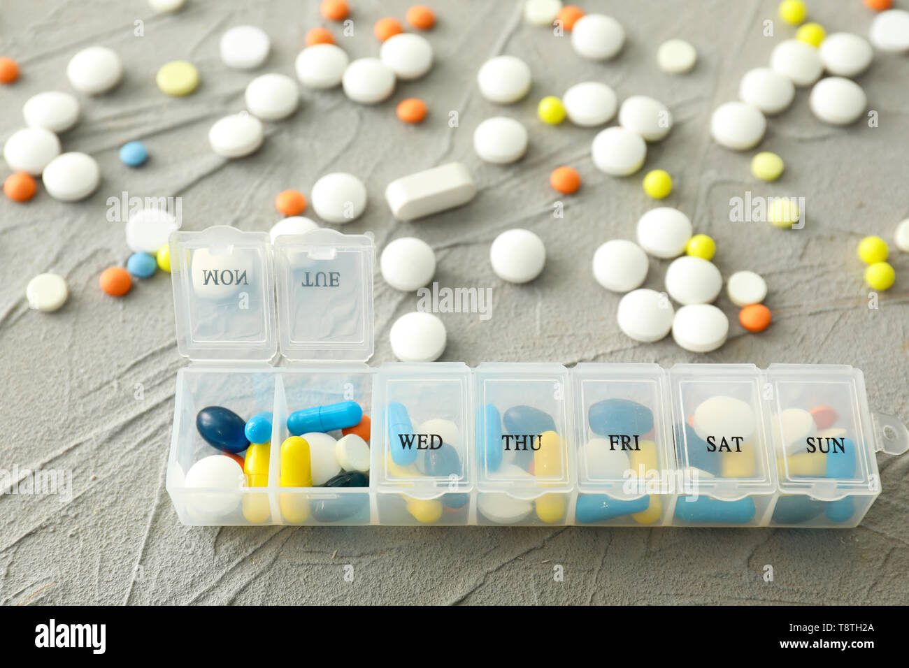 Plastic container with different pills on textured background Stock ...