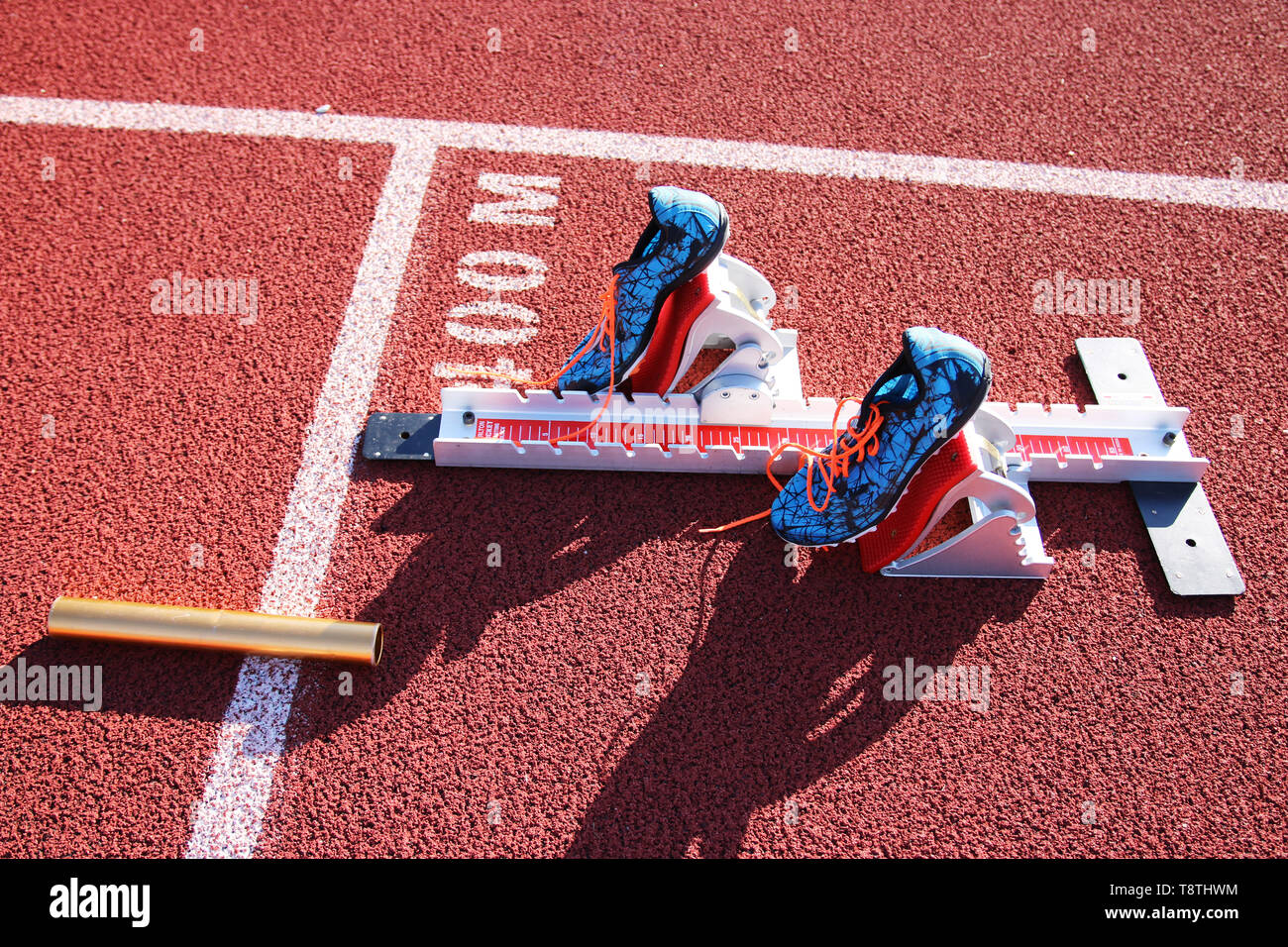 A set of starting blocks sits at the 400 meter start line on a red ...