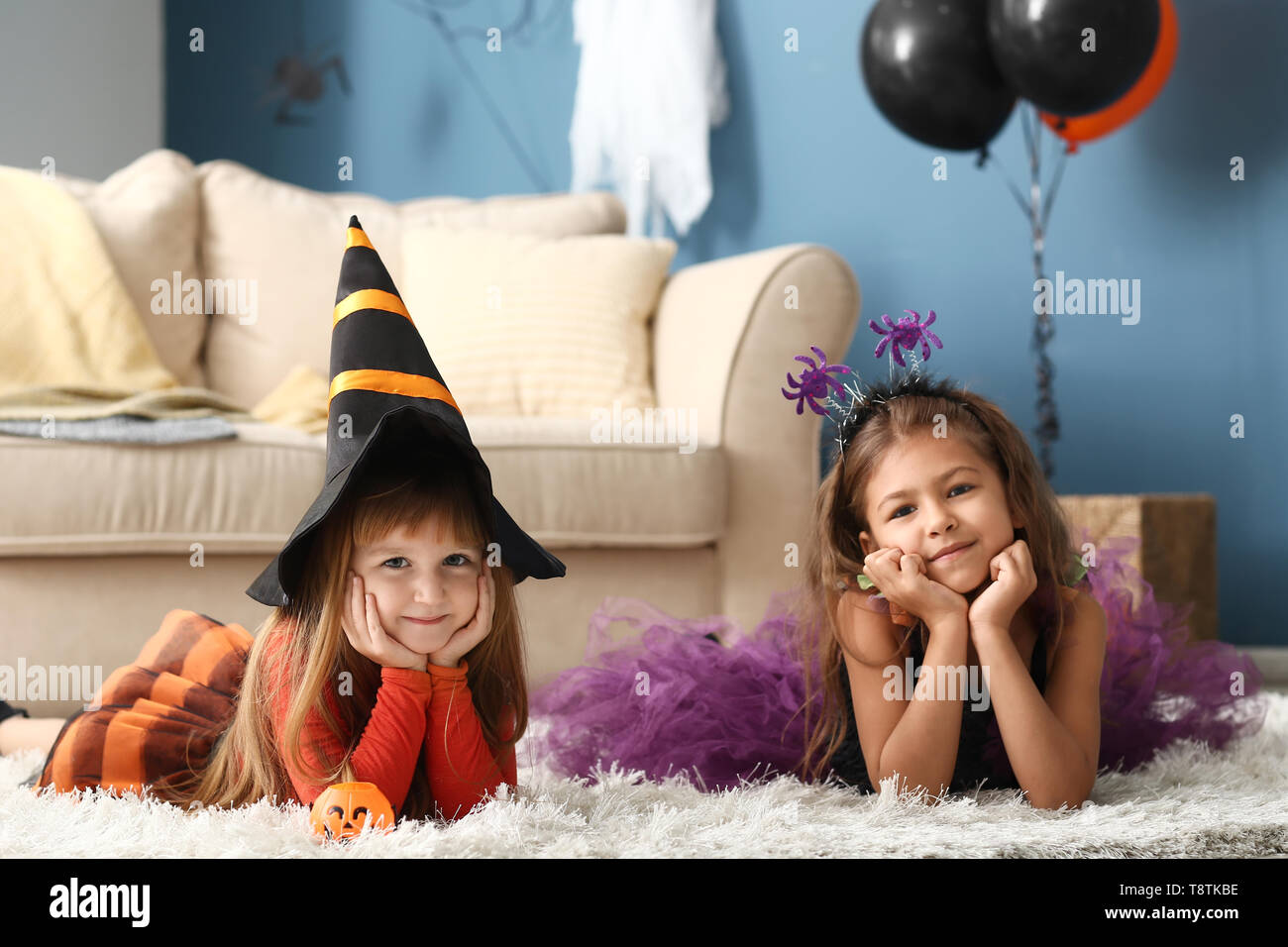 Cute little girls in Halloween costumes at home Stock Photo - Alamy