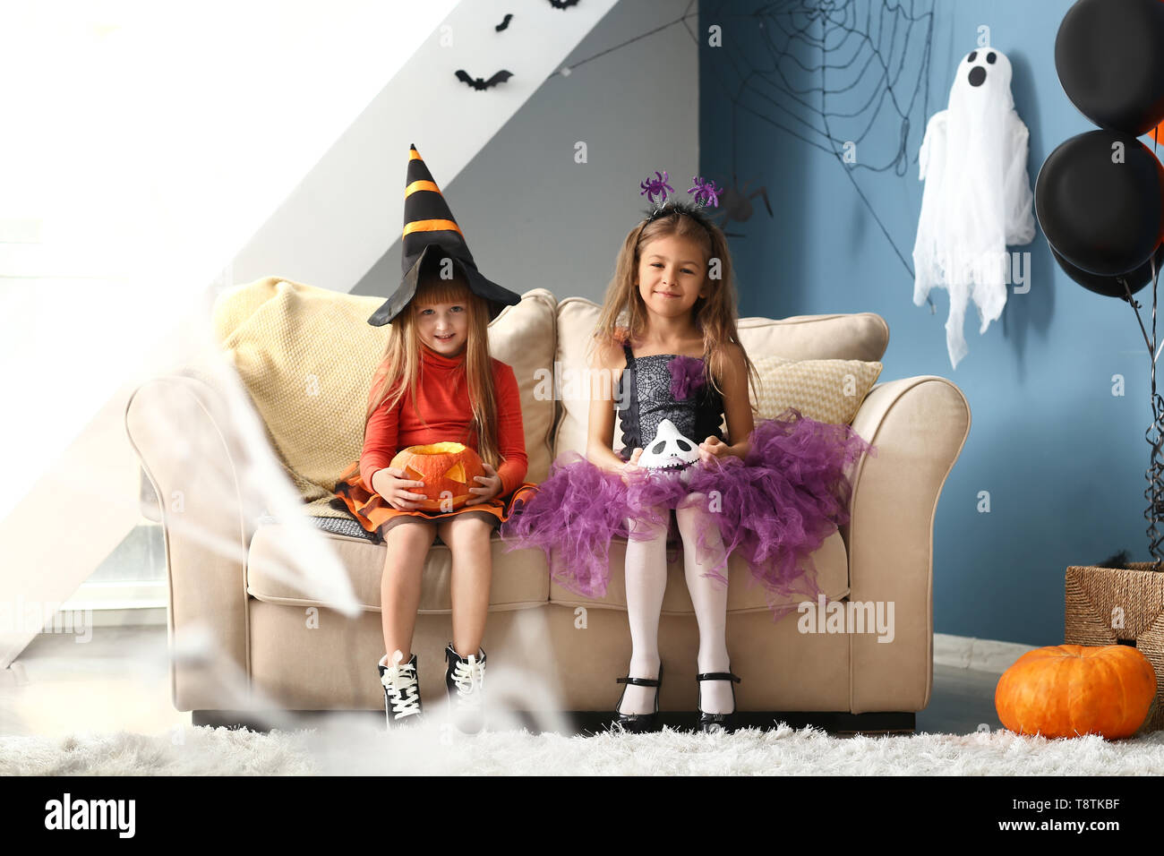 Cute little girls in Halloween costumes at home Stock Photo - Alamy