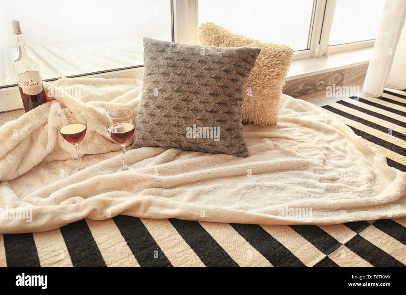 Cozy place for rest with soft pillows and wine near window Stock Photo ...