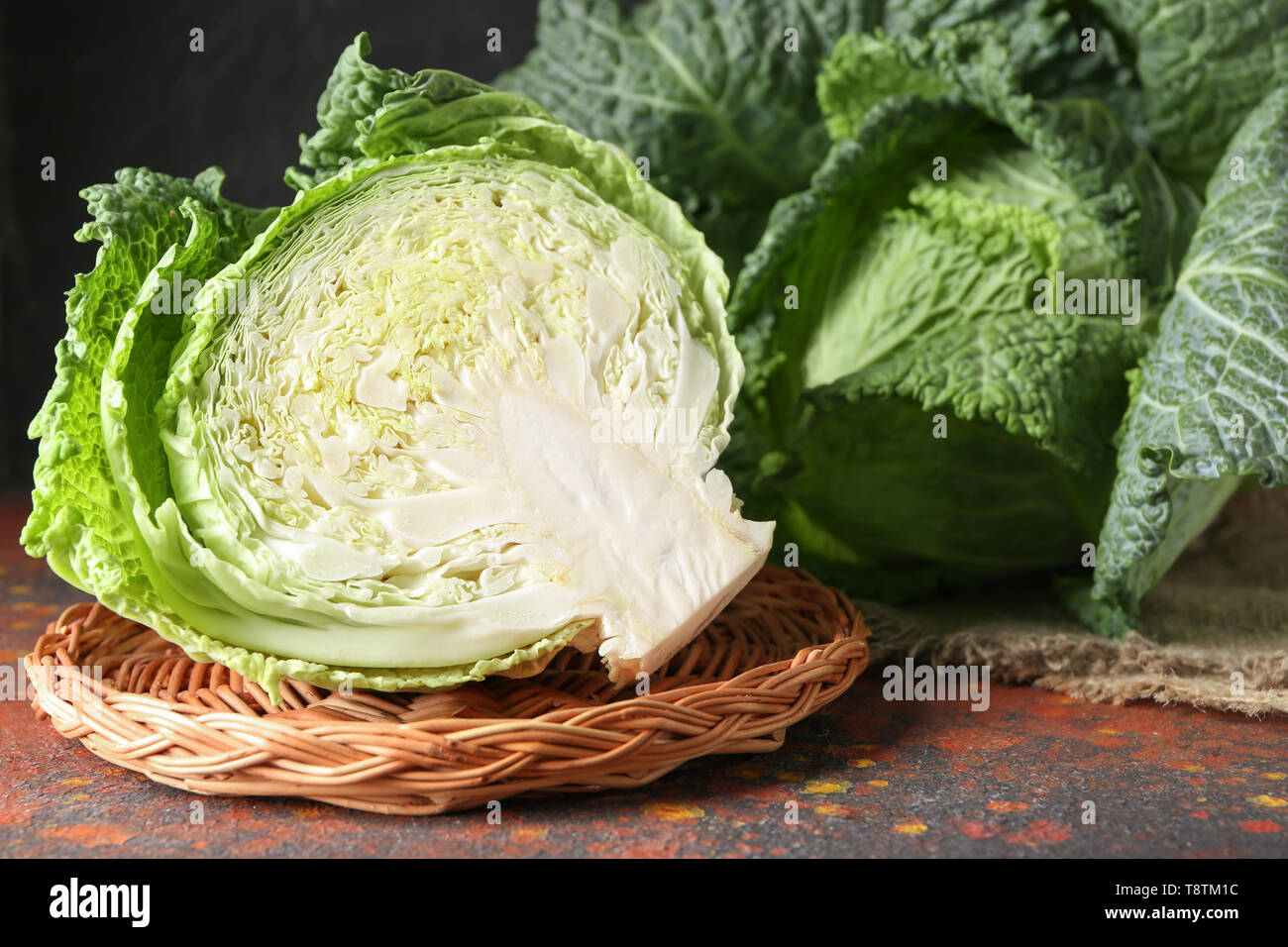 Whole and cut savoy cabbages on color table Stock Photo - Alamy