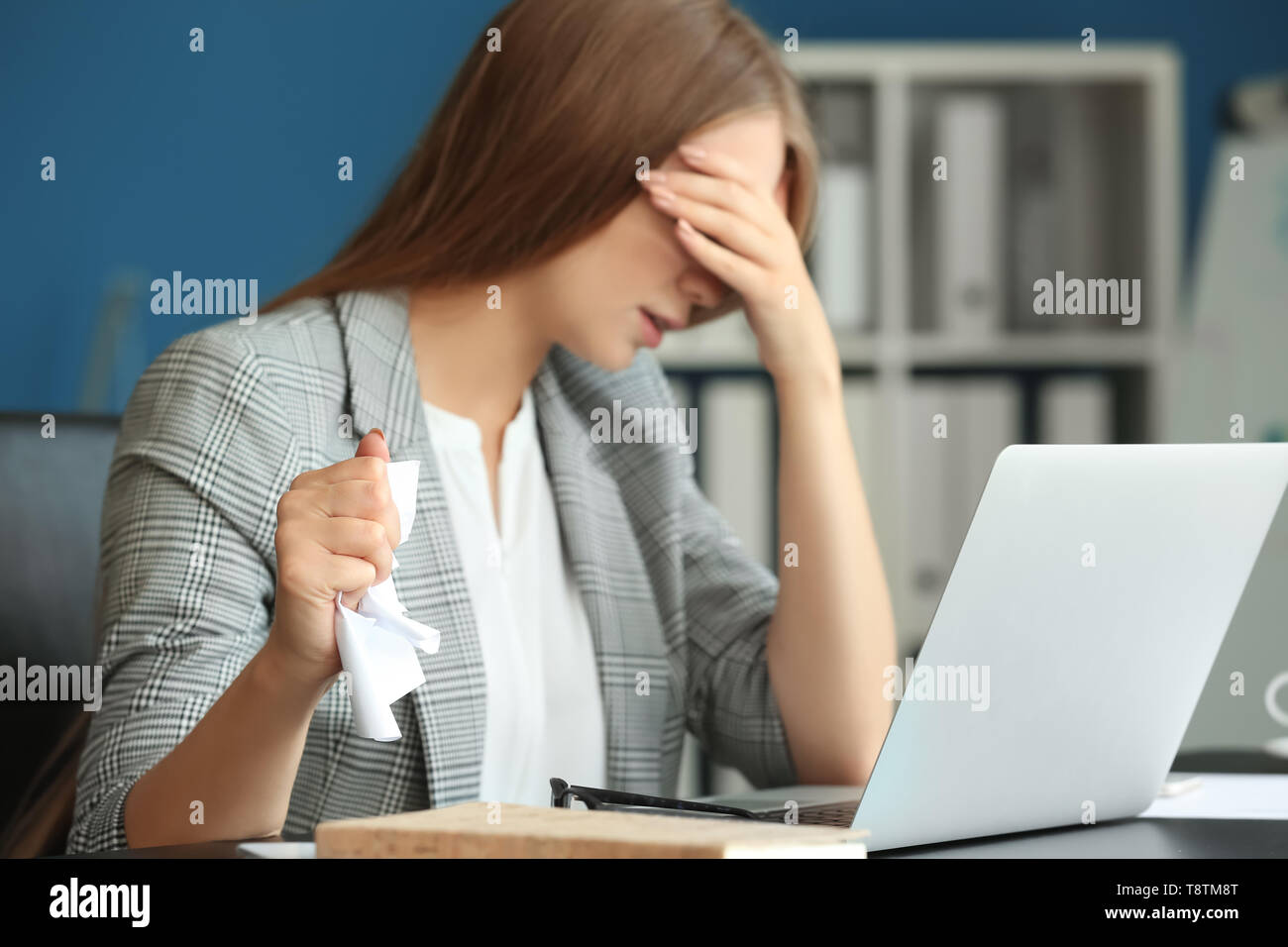 Stressed young woman with crumpled paper in office Stock Photo - Alamy